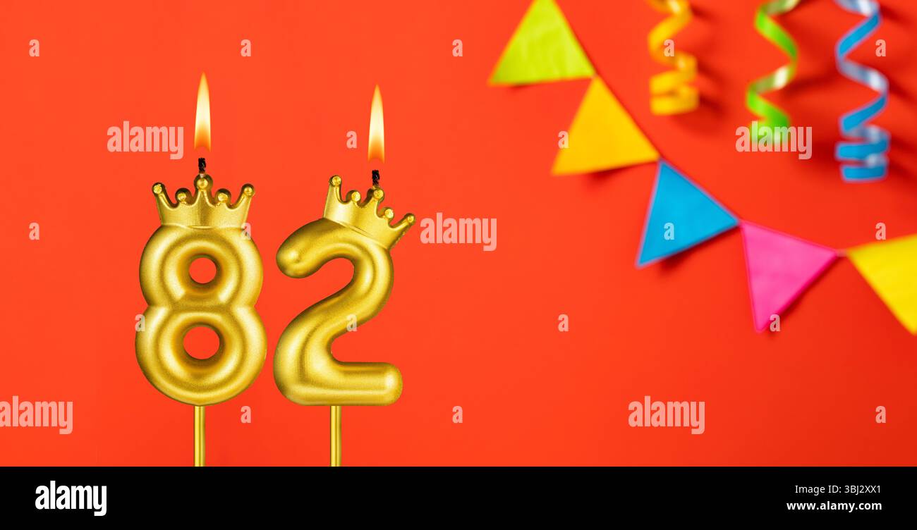 Number 82 candle - Birthday celebration on an orange background with ...