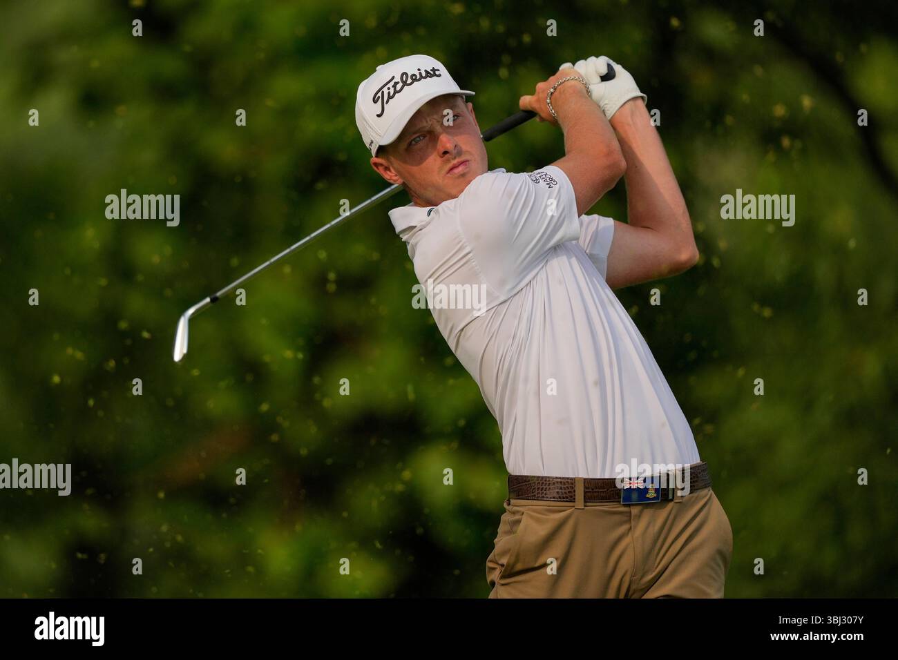 Justin Hastings, of the Cayman Islands, tees off on the 13th hole ...