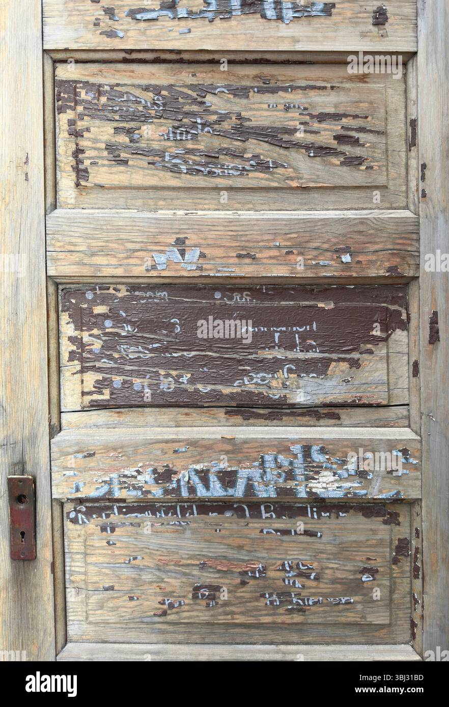 Closeup image shows old panel door with peeling paint and lettering ...
