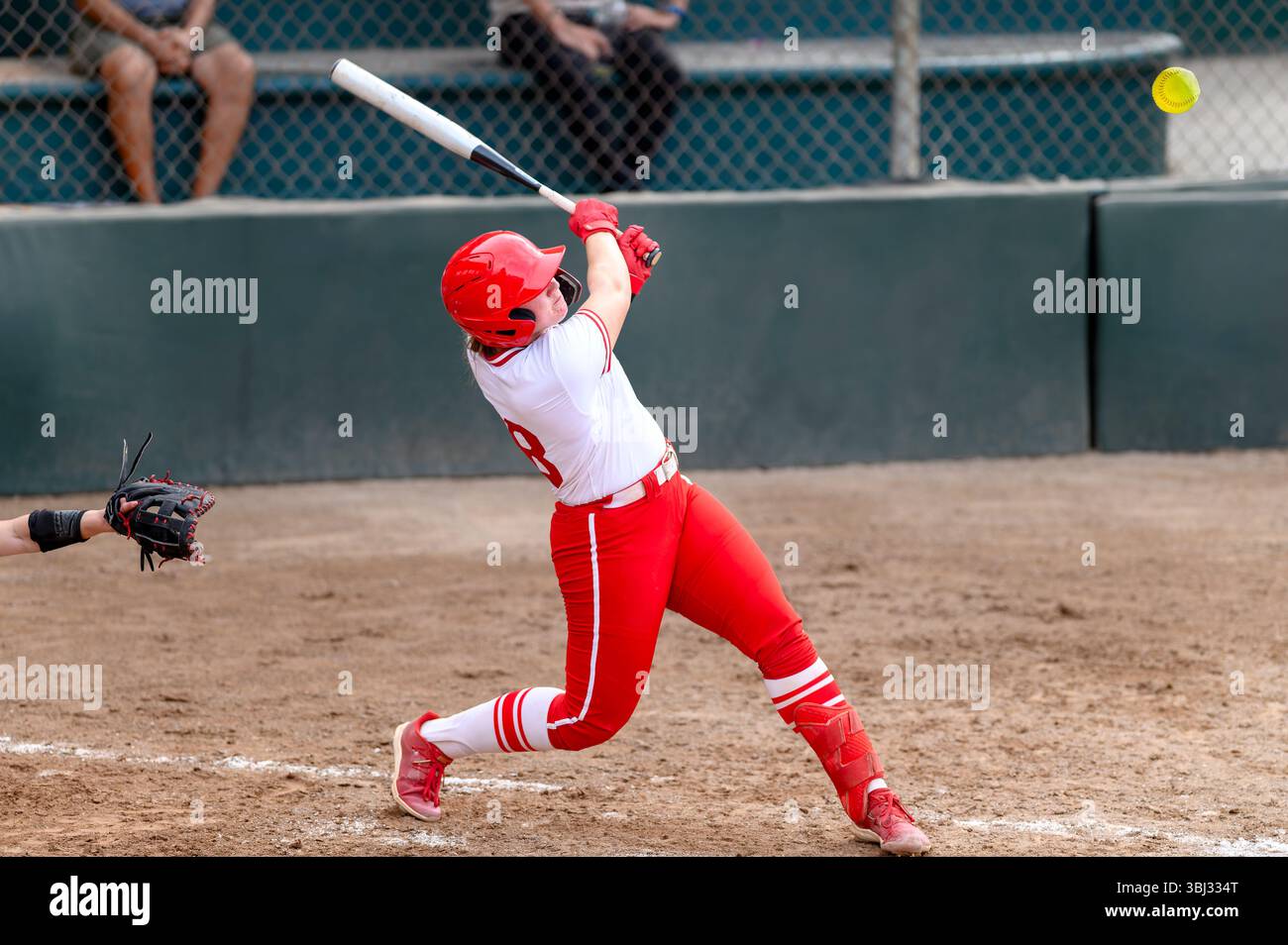 A Softball Player Is Swinging The Bat To Make Contact With The Baseball ...