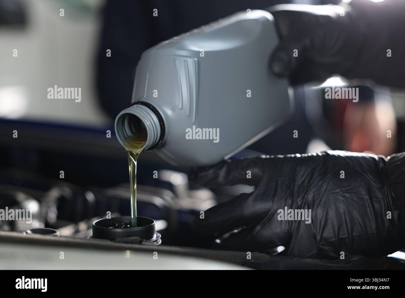 Worker pouring motor oil from canister into car engine, closeup Stock ...