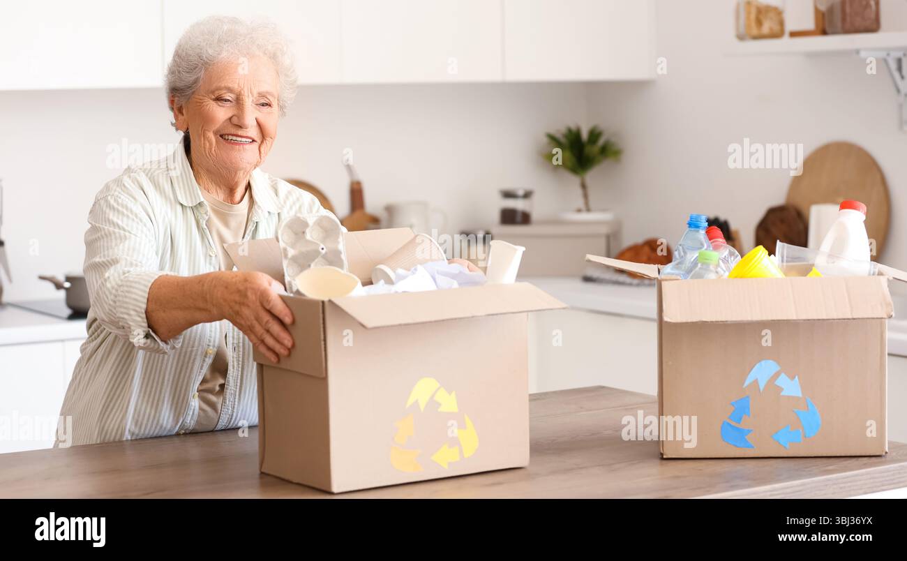 Senior woman sorting garbage in kitchen. Recycling concept Stock Photo ...