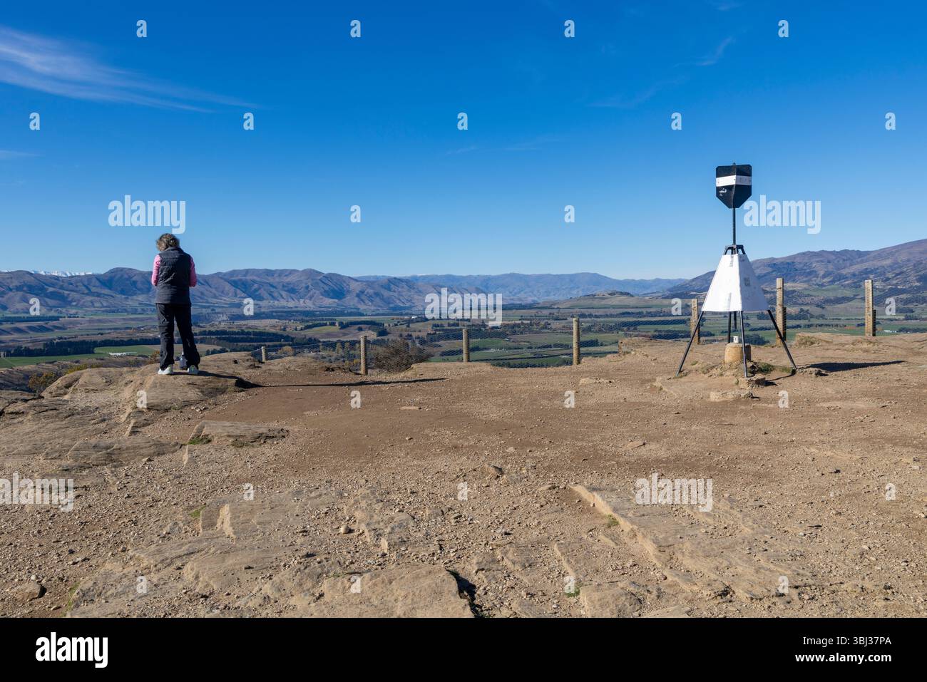 Wanaka, New Zealand, Mount Iron Reserve trig point with lady walker ...