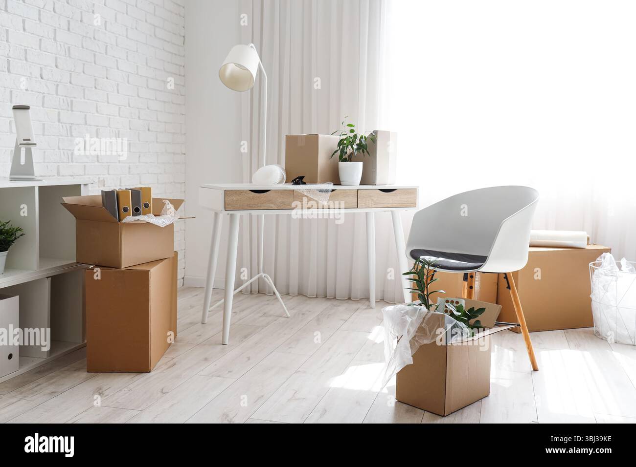Workplace with cardboard boxes in office on moving day Stock Photo - Alamy
