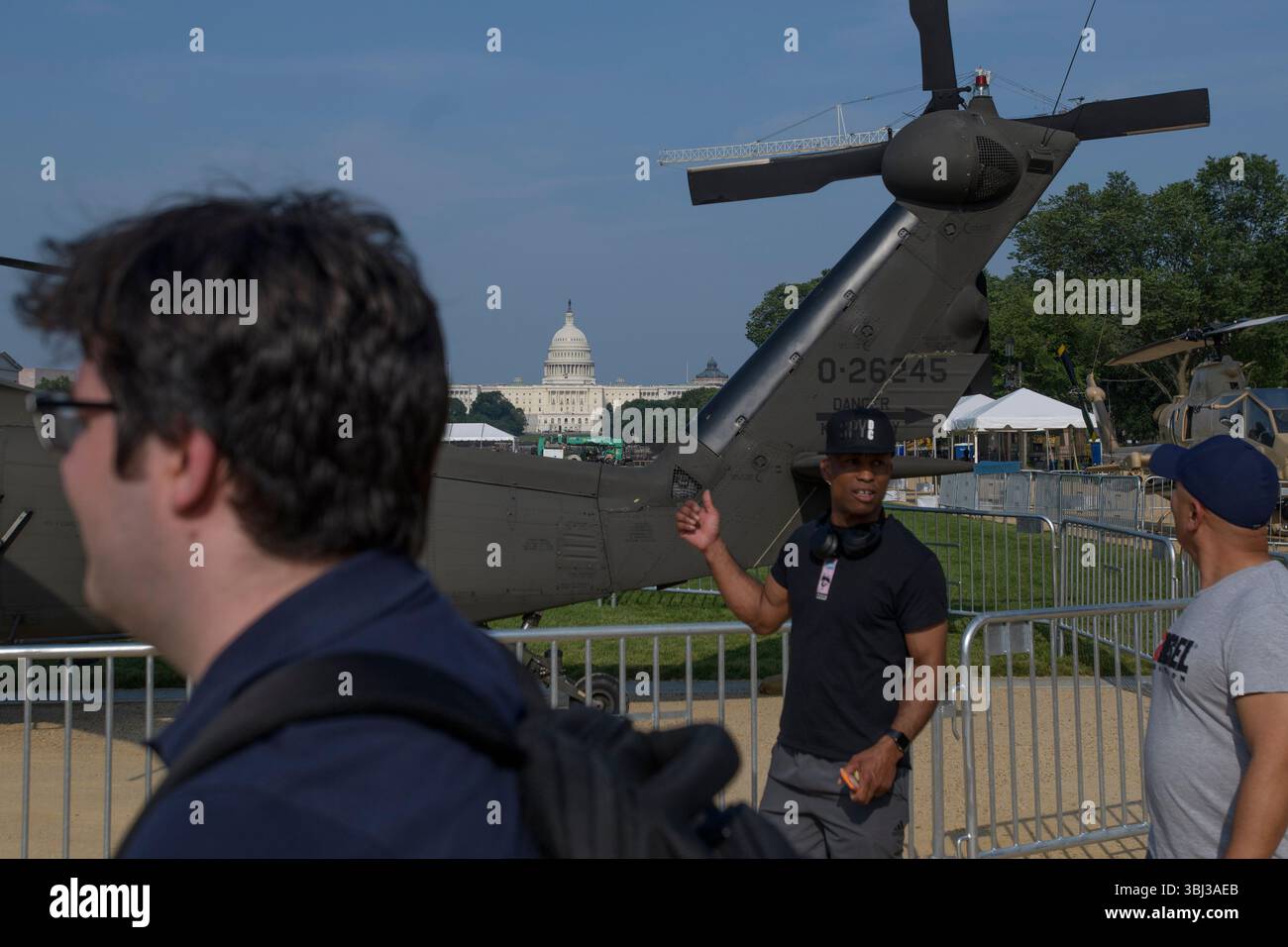 People pass by a military helicopter parked on the National Mall ...