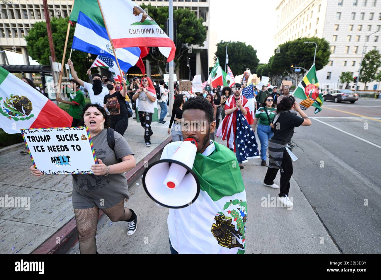 Demonstrators march in protest of recent ICE raids Thursday, June 12 ...