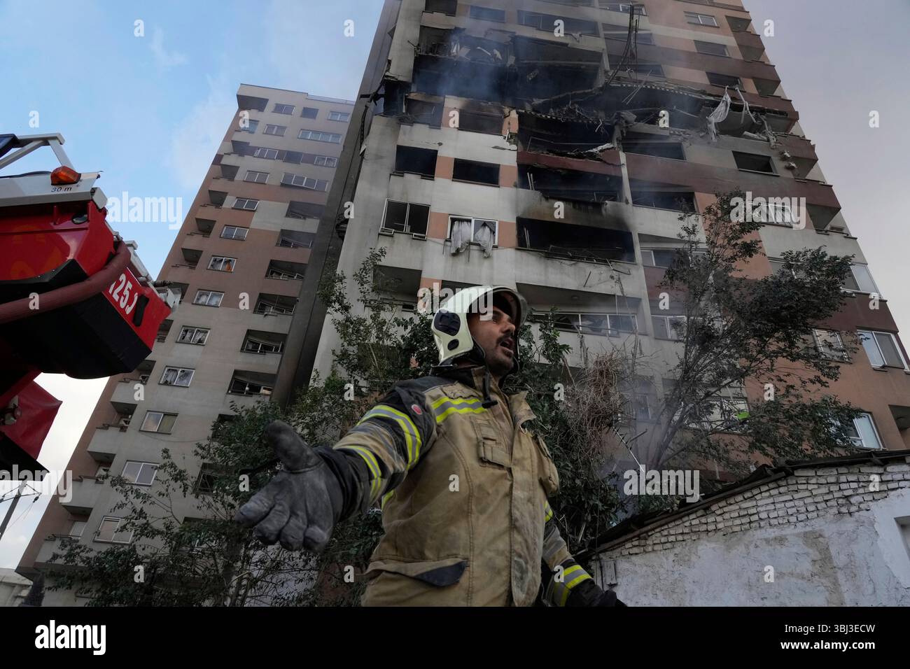 A firefighter calls out his colleagues at the scene of an explosion in ...