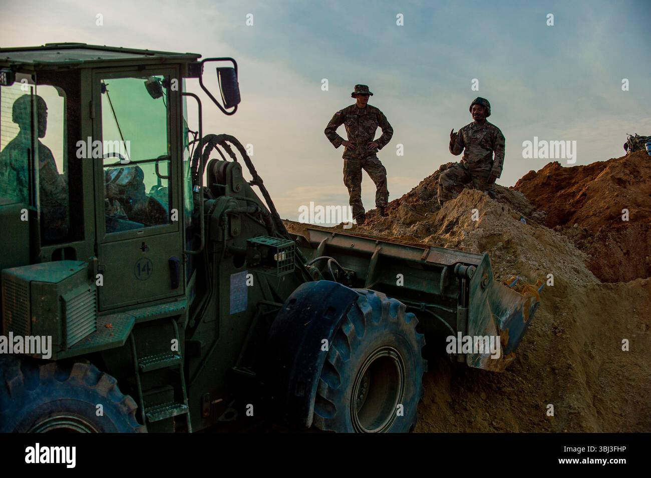 U.S. Army engineer Soldiers operate heavy machinery to construct an air ...
