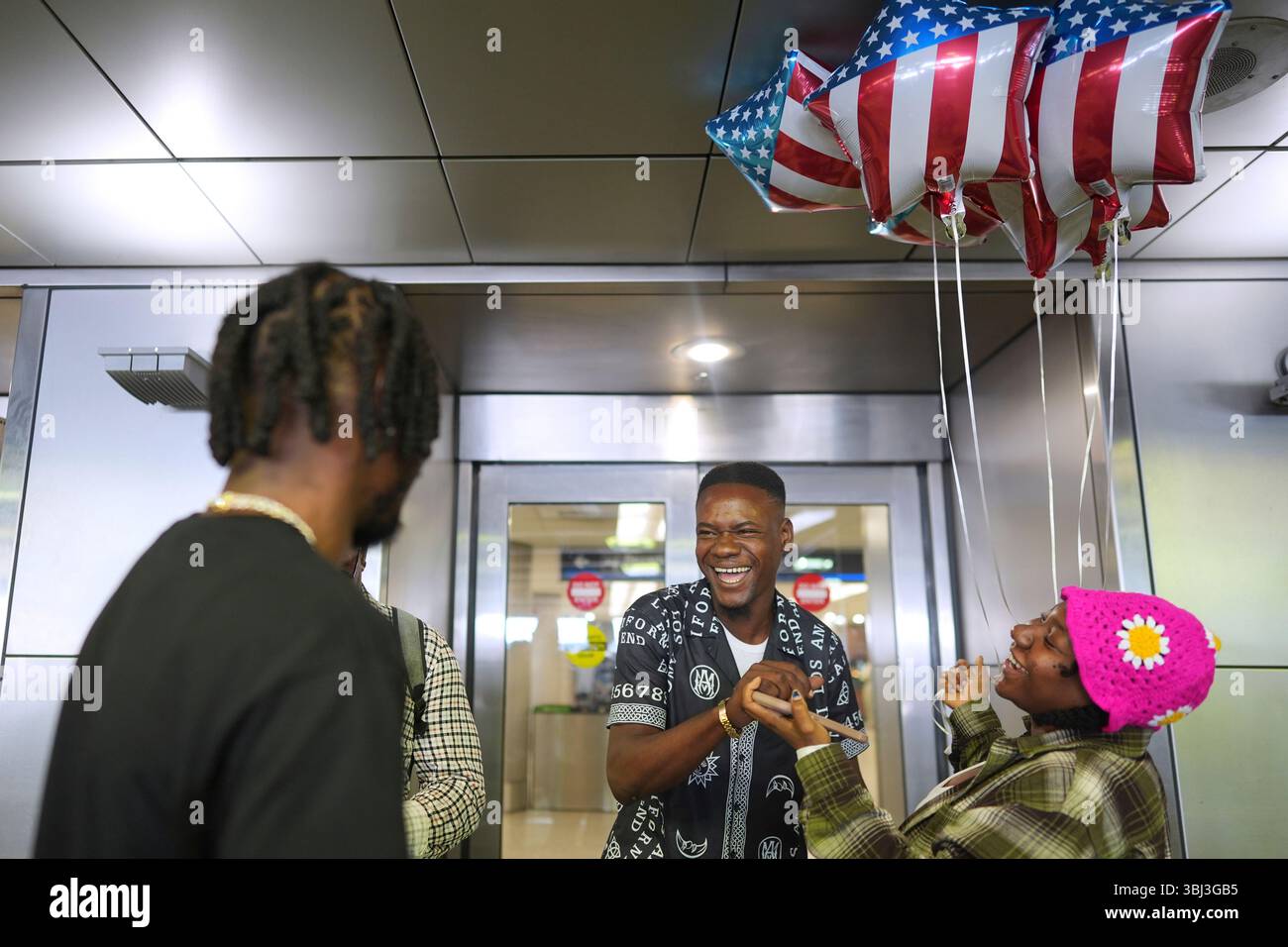Key Felix, center, of Haiti, is greeted by his sister, carrying ...