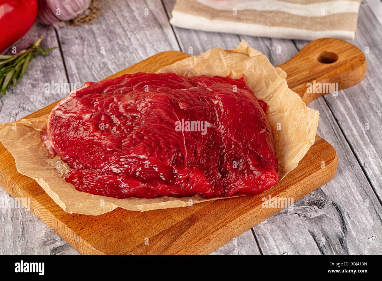Raw beef meat fillet for cooking over boats served rostmary and napkin ...