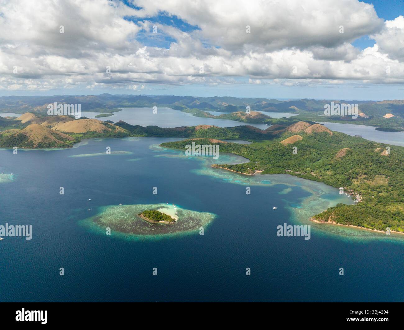 Tourist boats in CYC Beach. Uson Island with turquoise sea water and ...