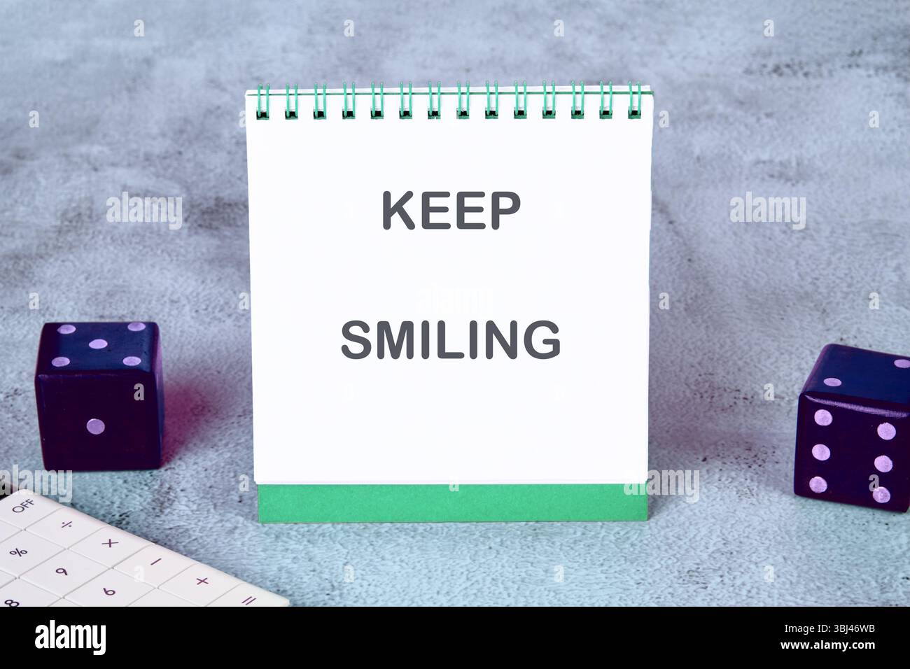 KEEP SMILING words written on a desktop notebook, surrounded by a ...