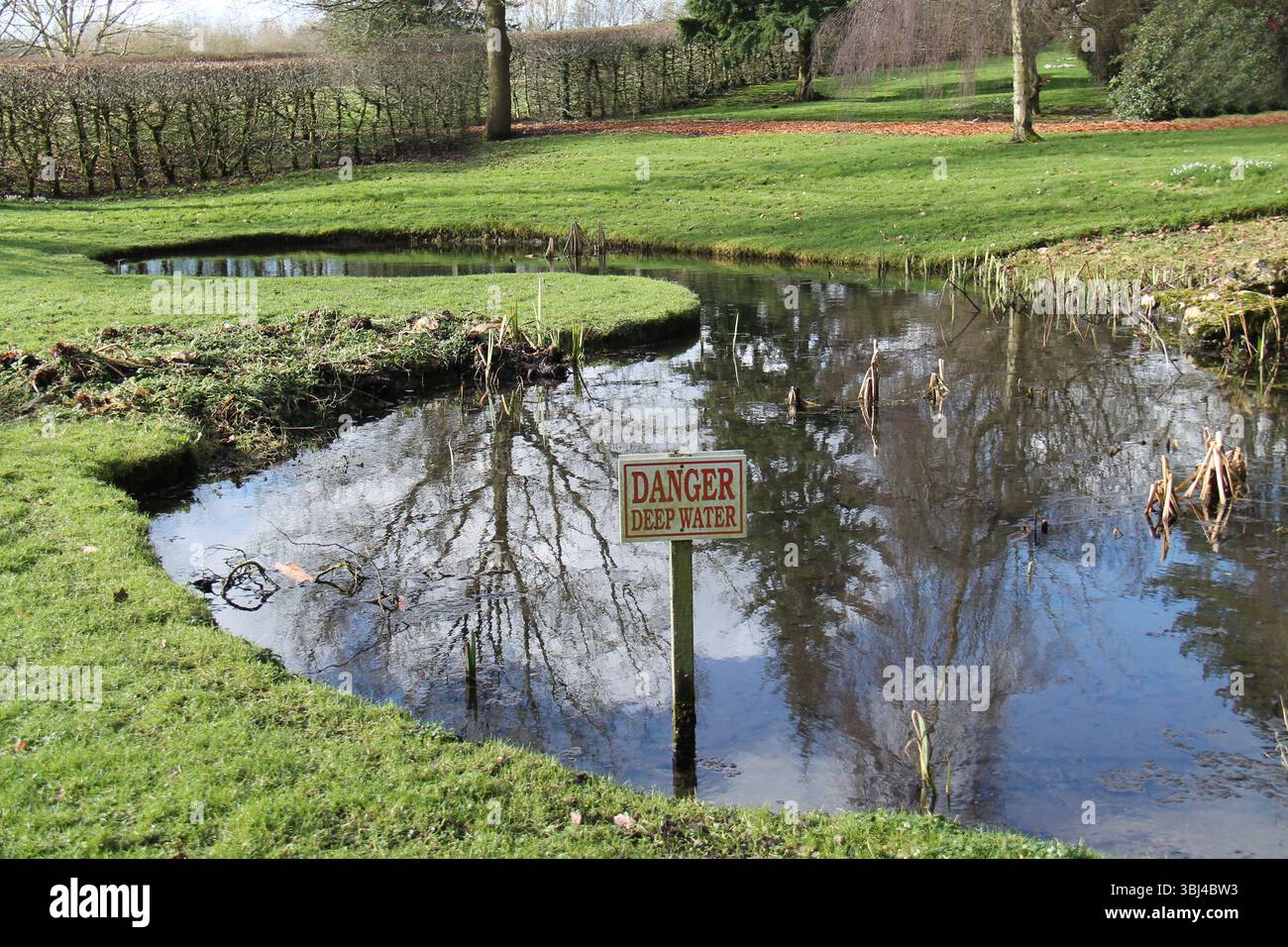 A Warning Sign for a Large Deep Garden Pond Stock Photo - Alamy