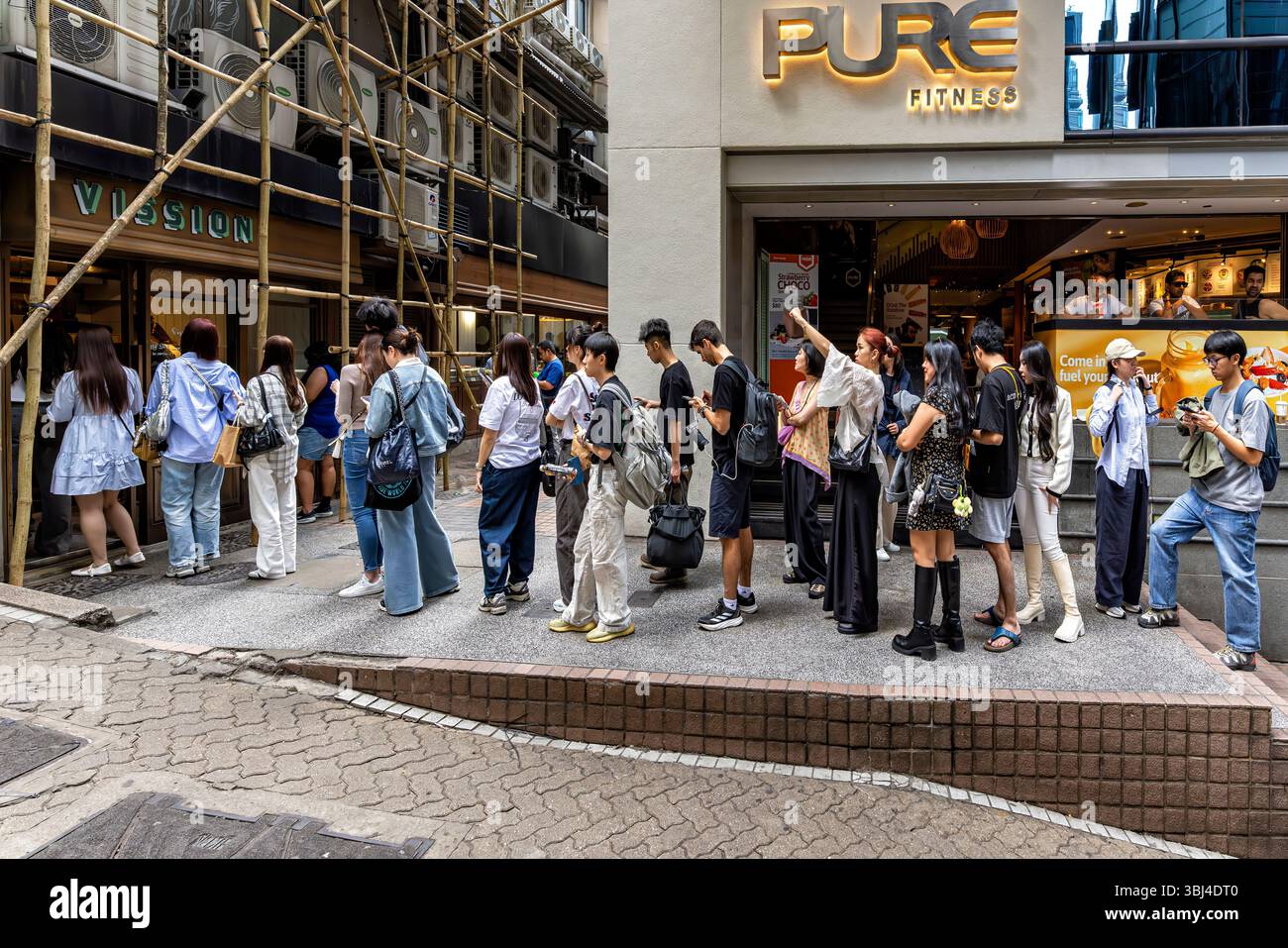Tourists in long queue in street for bakery, Mid-Levels, Hong Kong, SAR ...