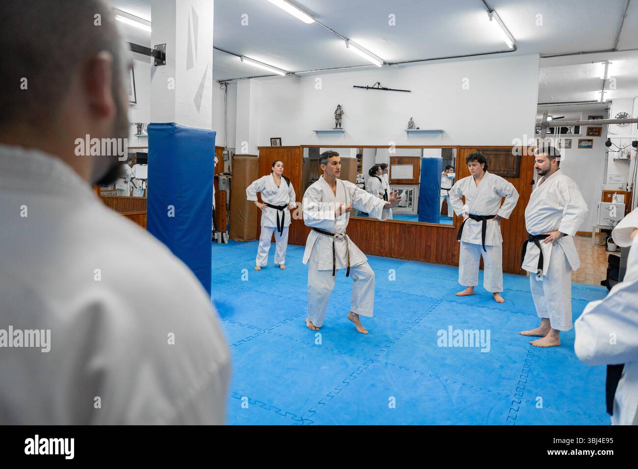 Karate instructor explaining new training technique to students ...