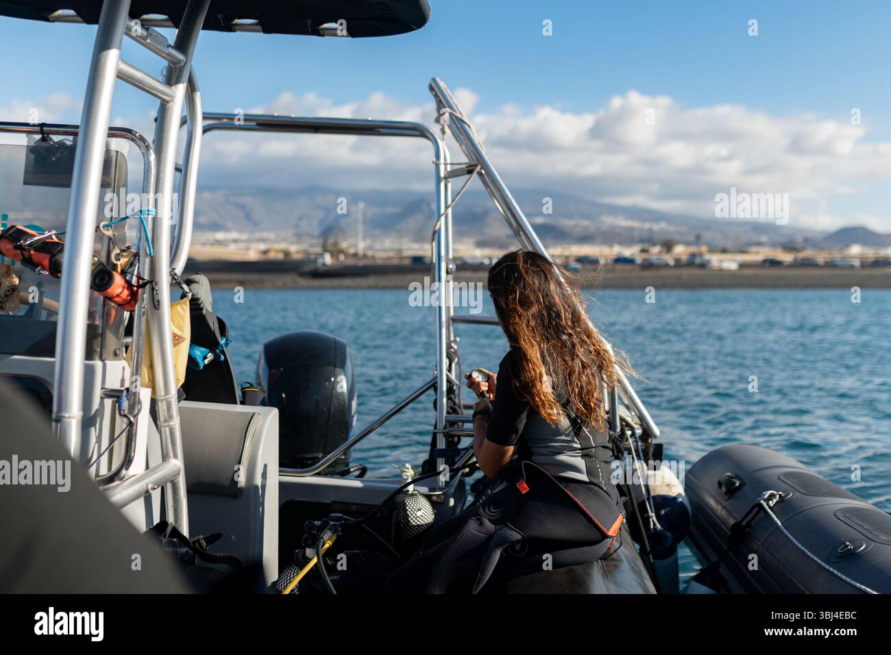 Female scuba diver preparing equipment on a boat, ready for diving in ...
