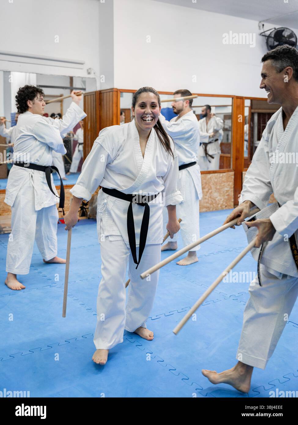 Smiling karate students practicing with bokken during martial arts ...