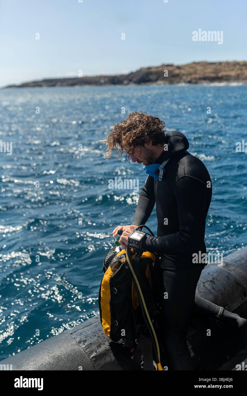 Scuba diver checking his equipment on a boat, getting ready for a dive ...