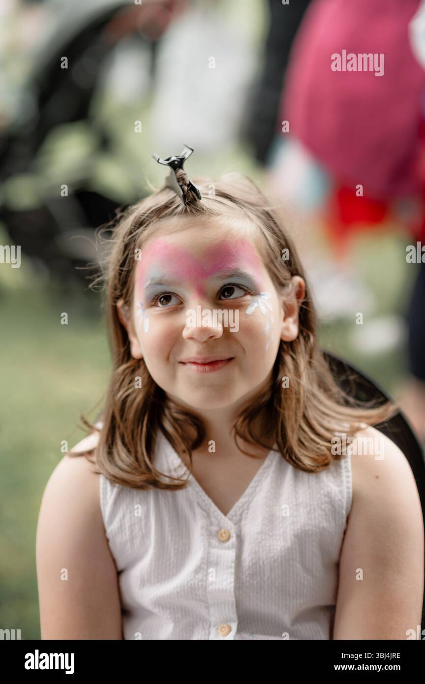 Smiling child girl waiting for the next part of her face painting Stock ...
