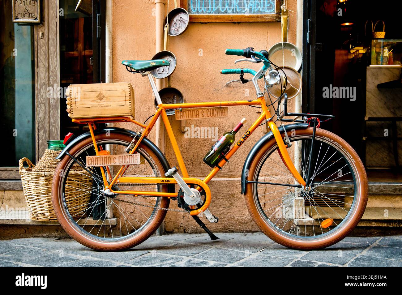 An orange-yellow classic bicycle is parked in front of a charming ...