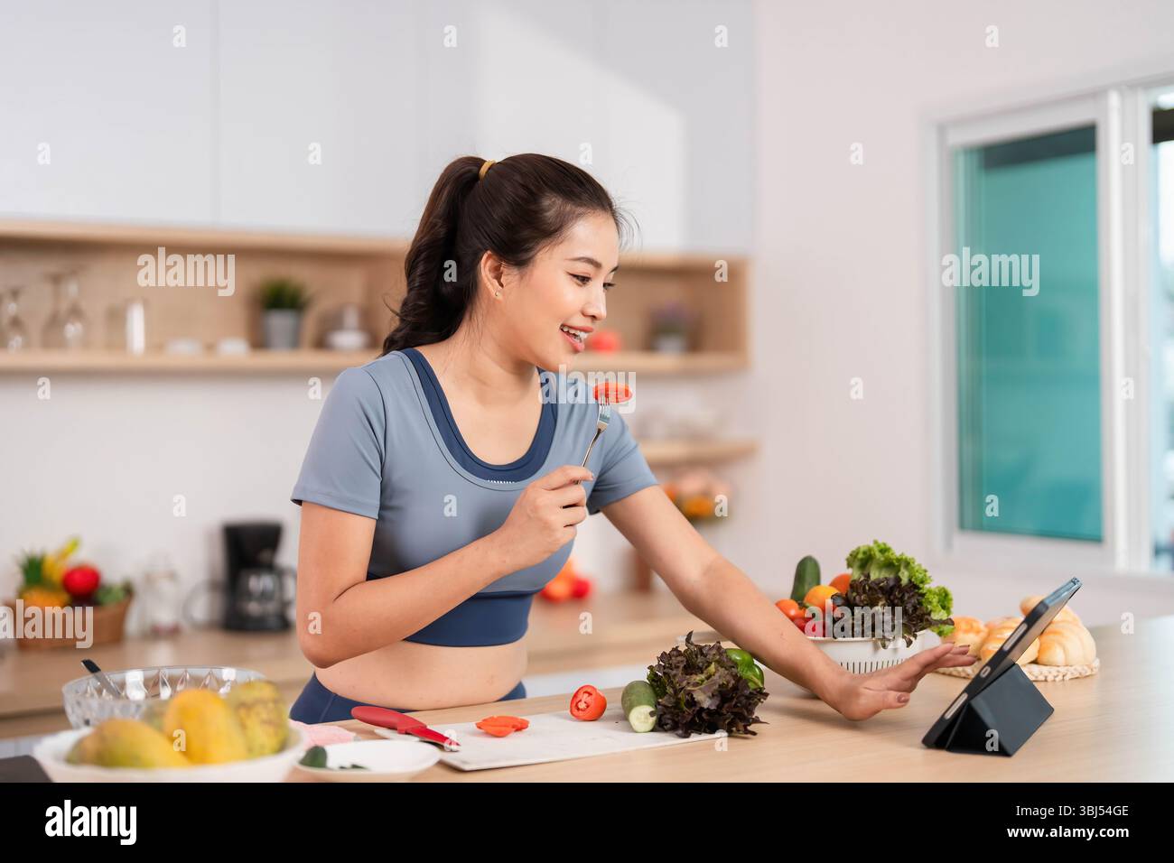 ESG and Culinary Skills. Woman multitasking with tablet while enjoying ...