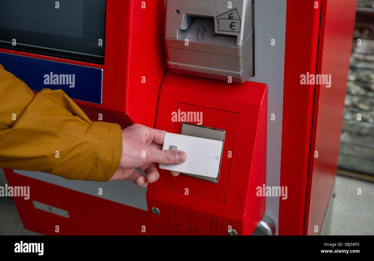 Person using contactless card at red ticket vending machine on train ...