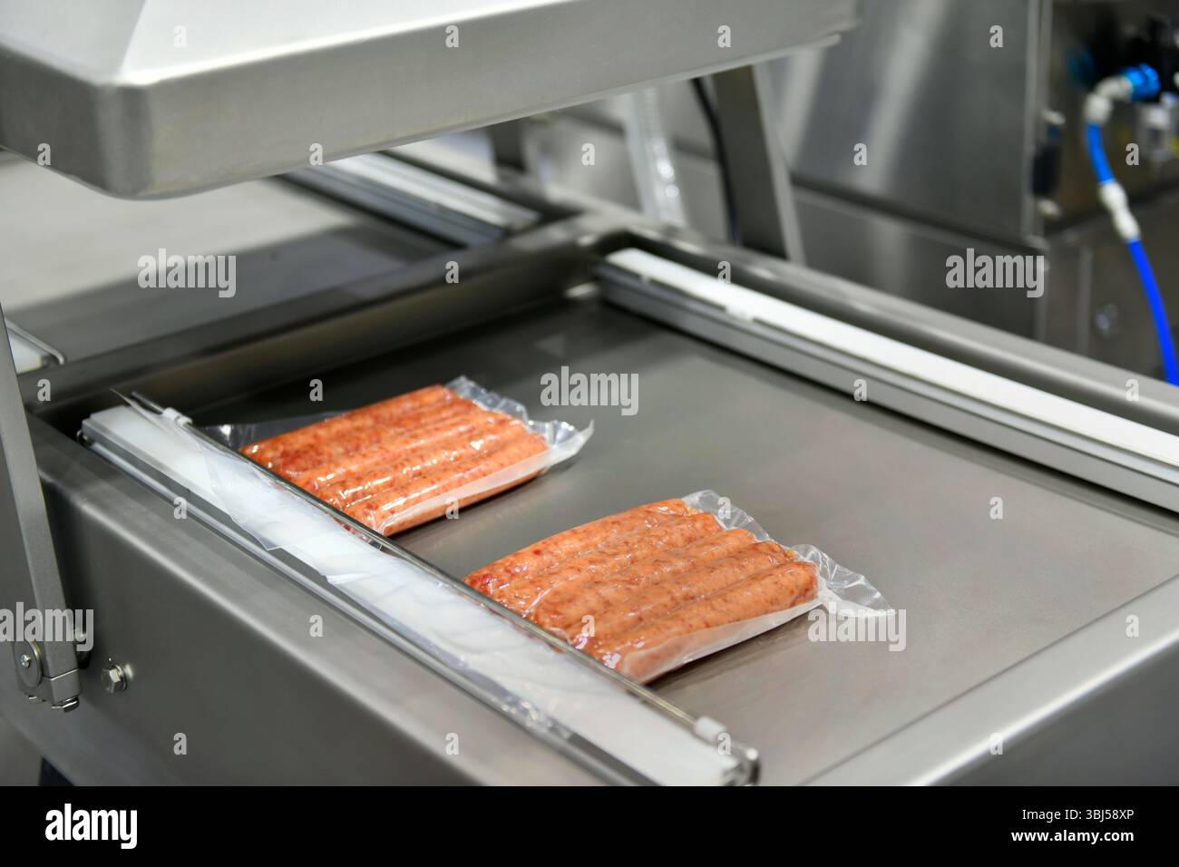 High-performance machines are wrapping processed fresh food products sausages. food production ...