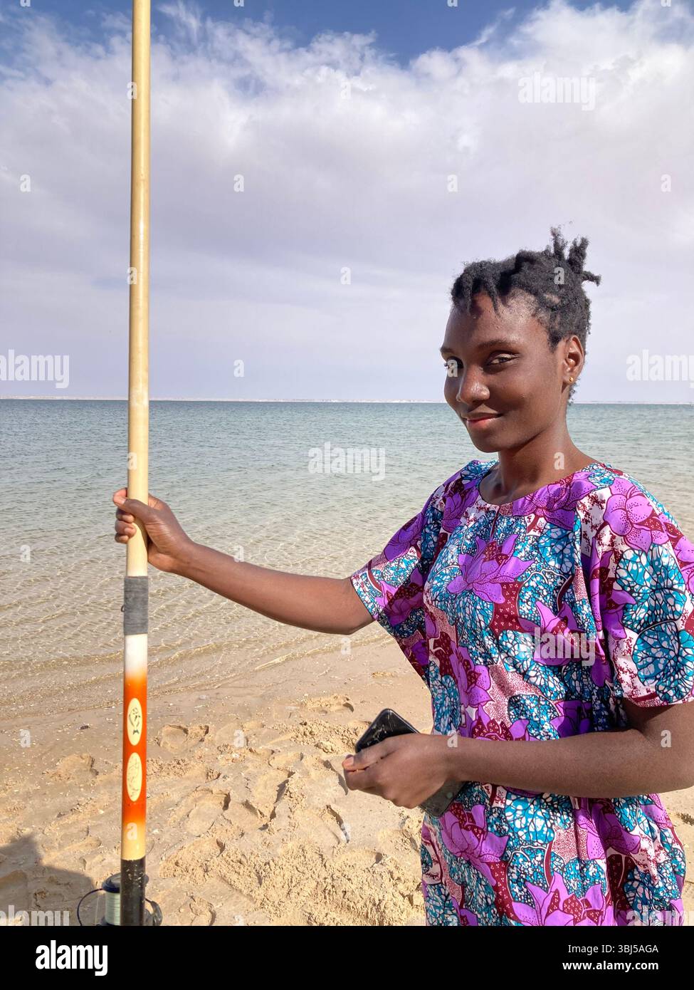 Black woman with a fishing rod at the lagoon beach, Dakhla, Western ...