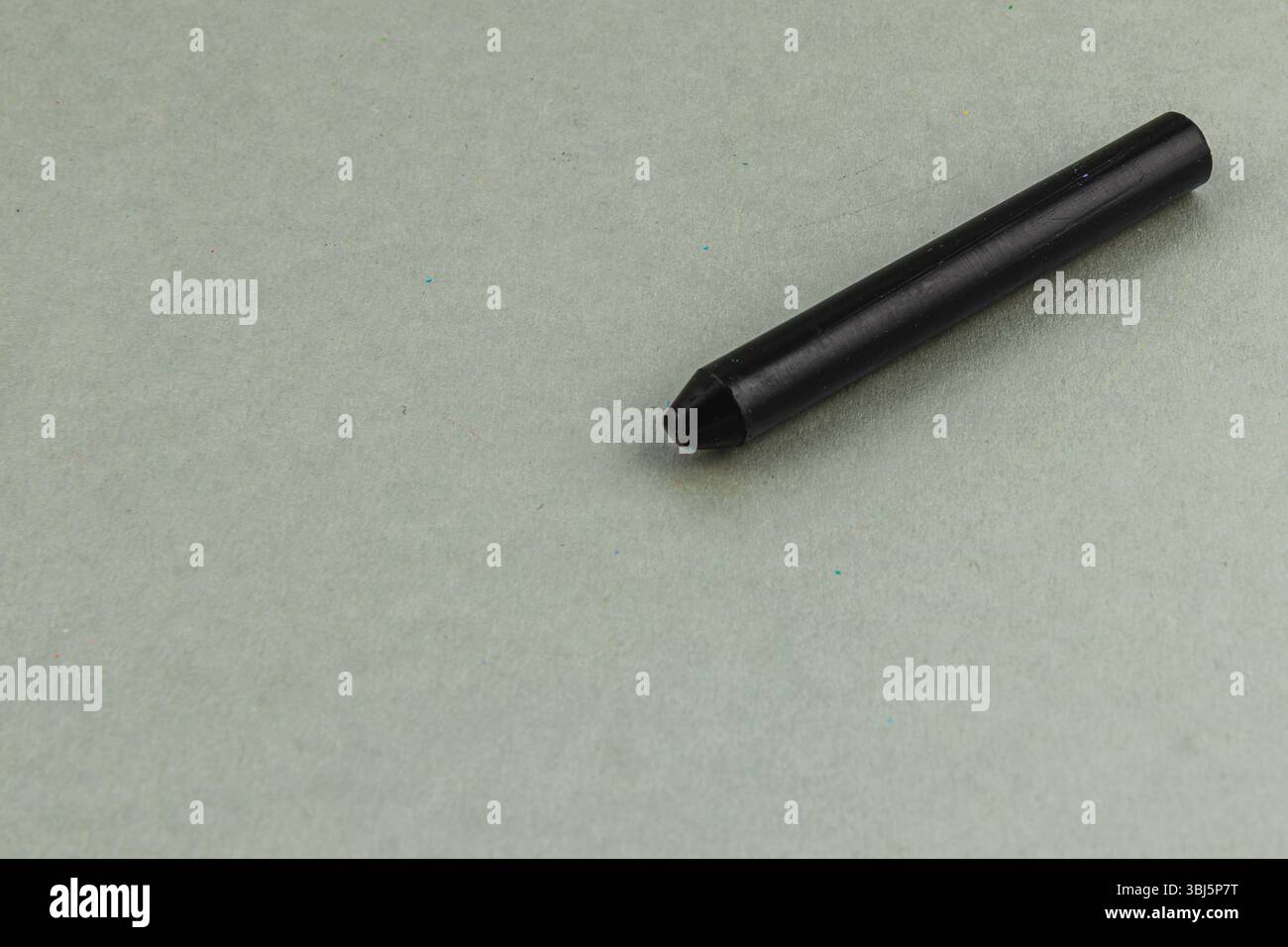 A black drawing tool is placed on a light-colored surface, showcasing ...