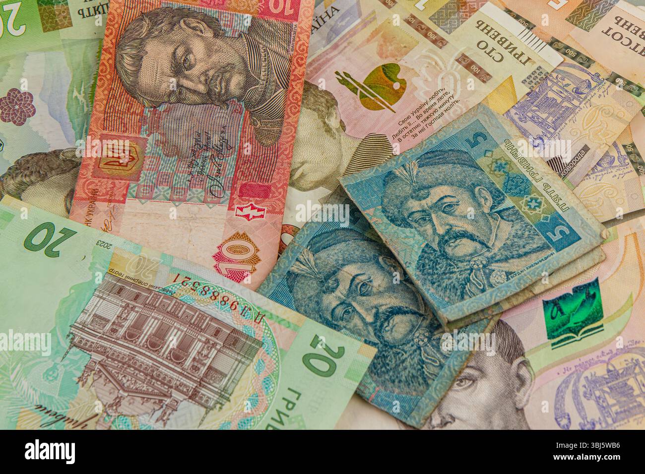 Various denominations of Ukrainian banknotes are spread across a ...