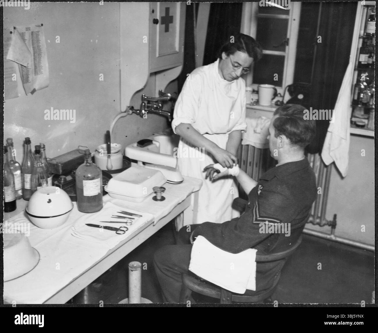 WAAF aviator Ethel 'Hoppy' Hopkins, bandaging the hand of an RAF ...