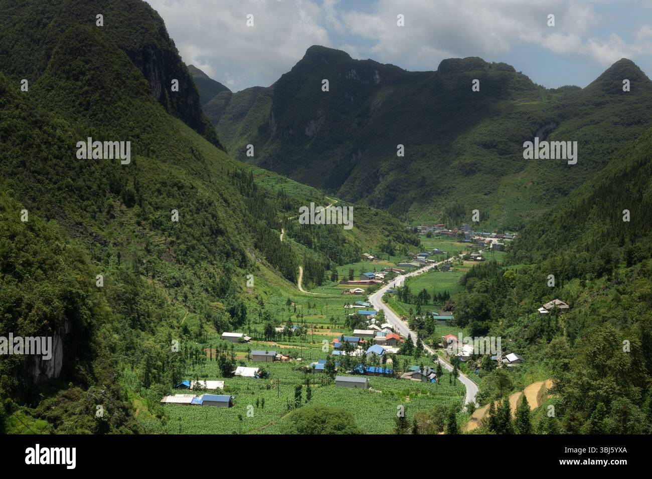 Lung Cam Tren village in a scenic green valley among forested karst ...
