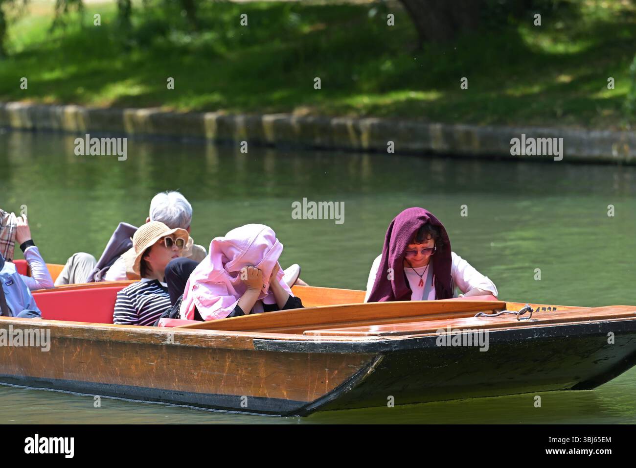 Hot UK Weather Visitors to Cambridge UK enjoy riding on Punts through ...
