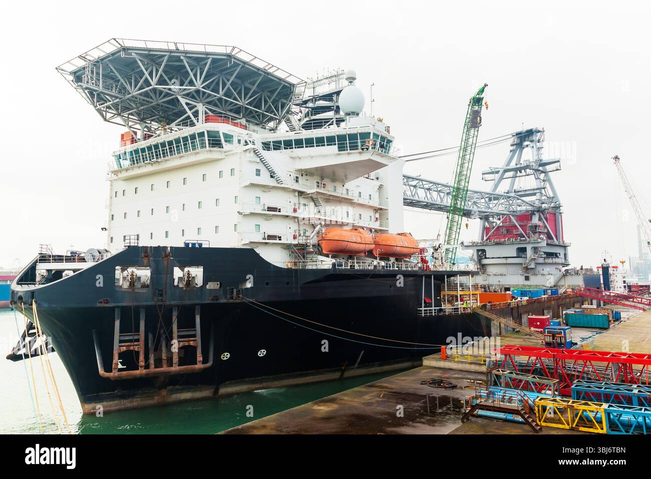 A large offshore floating crane vessel with a crane and a helipad is ...