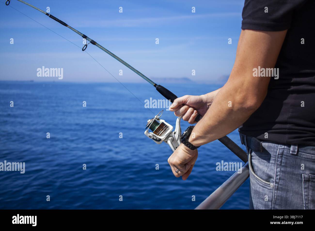 Close-up of man's hand holding fishing rod in the sea, man fishing ...