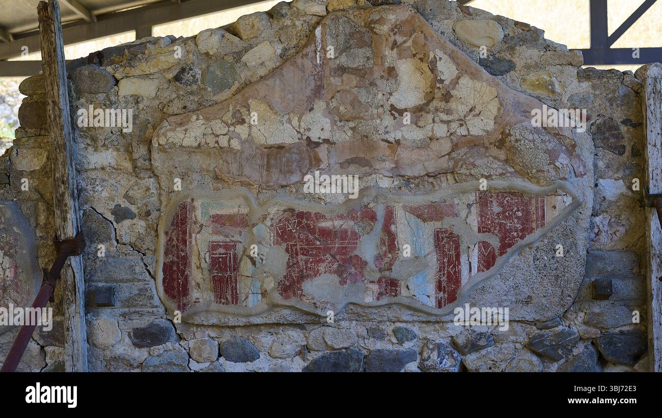 Ancient worn wall remnant with red drawings on stone wall ...