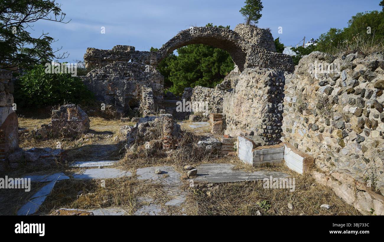 Ruins of an ancient site with stone arches and overgrown walls ...