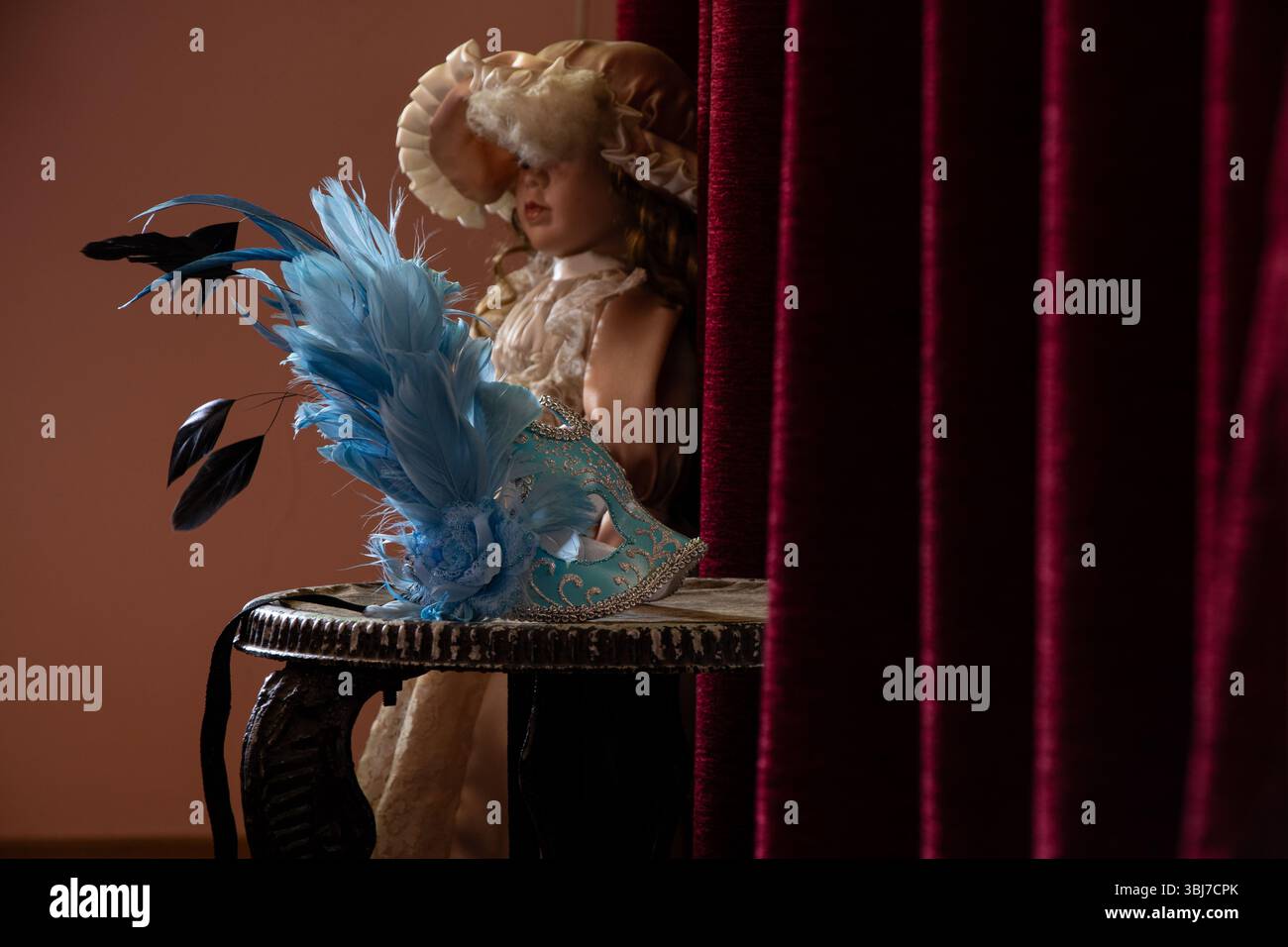 Carnival mask lies on a chair and a red curtain and behind there is a ...
