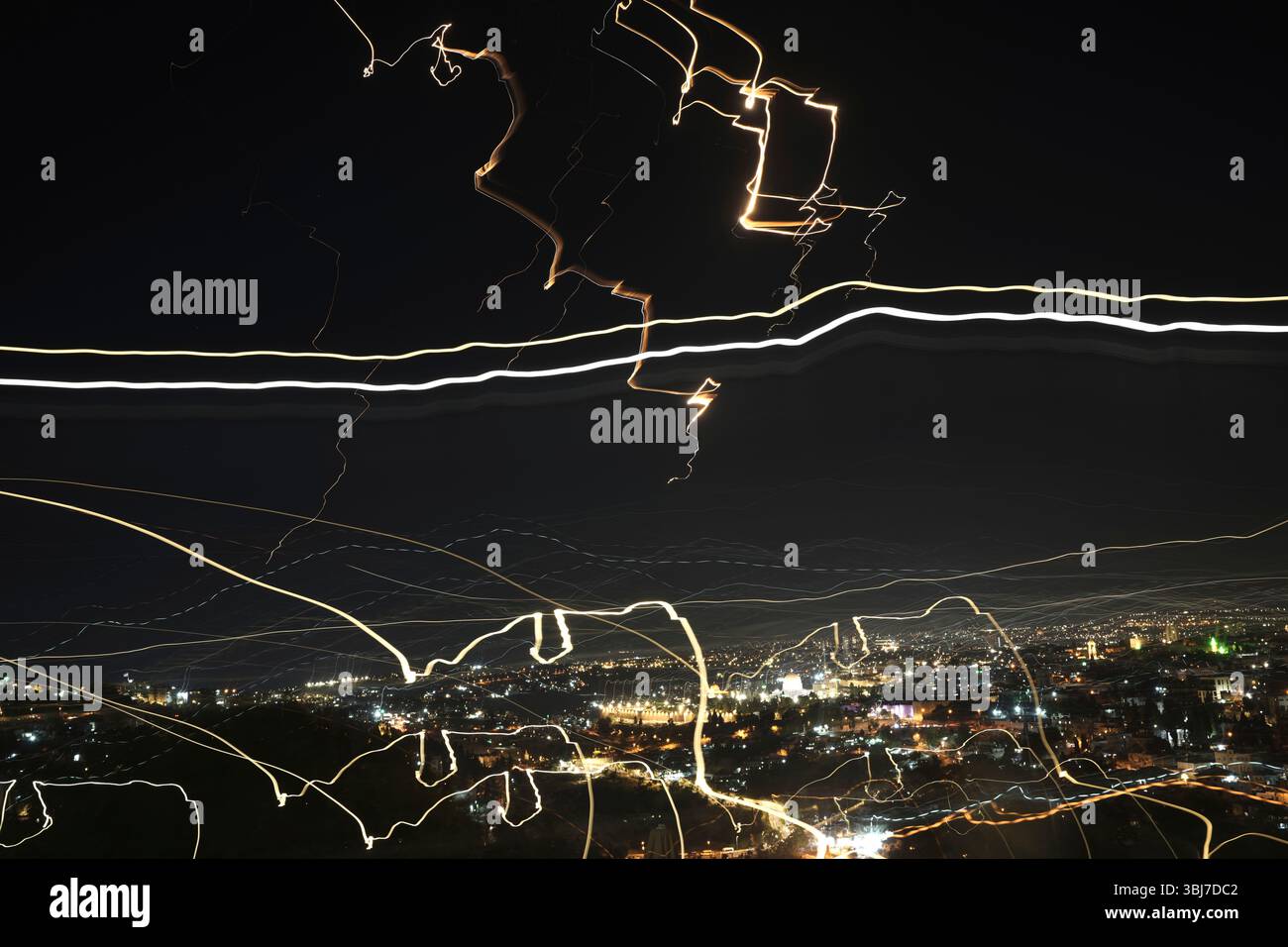 In this image taken with a slow shutter speed, projectiles light up the ...