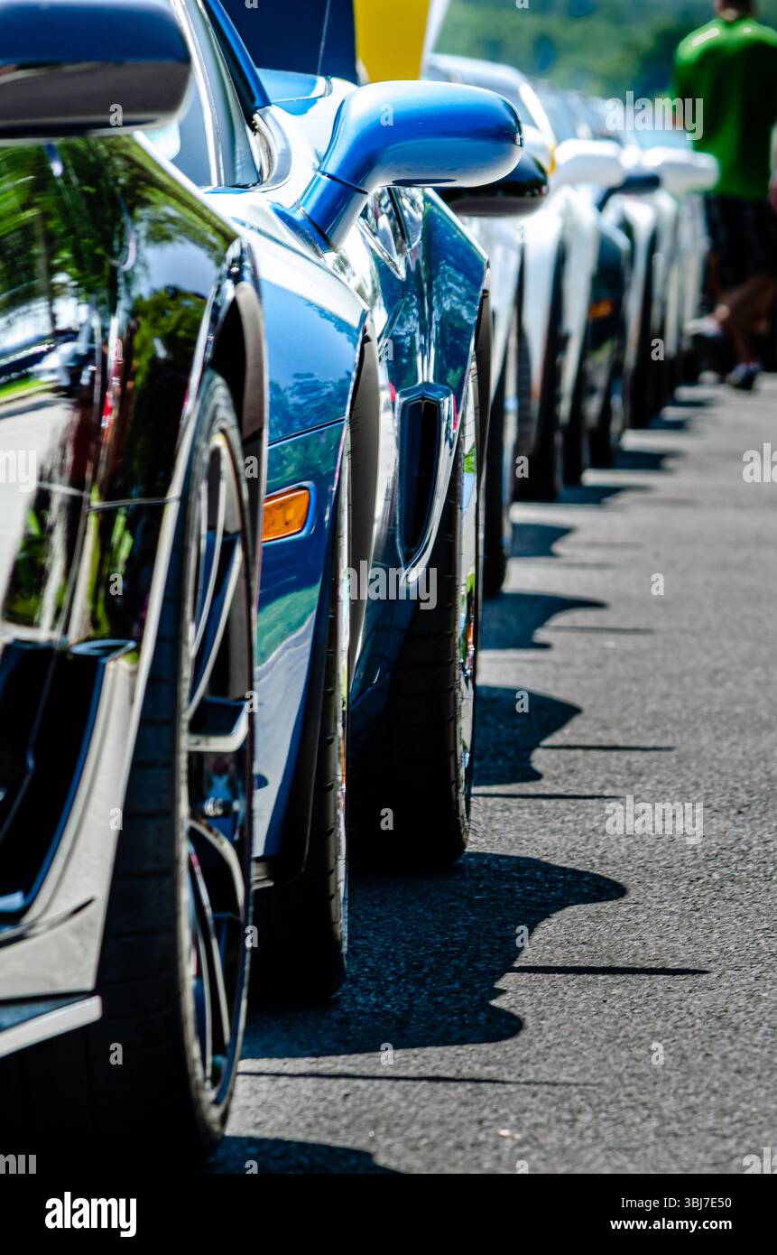 Low angle side view of a line of sports cars on a roadway in the ...