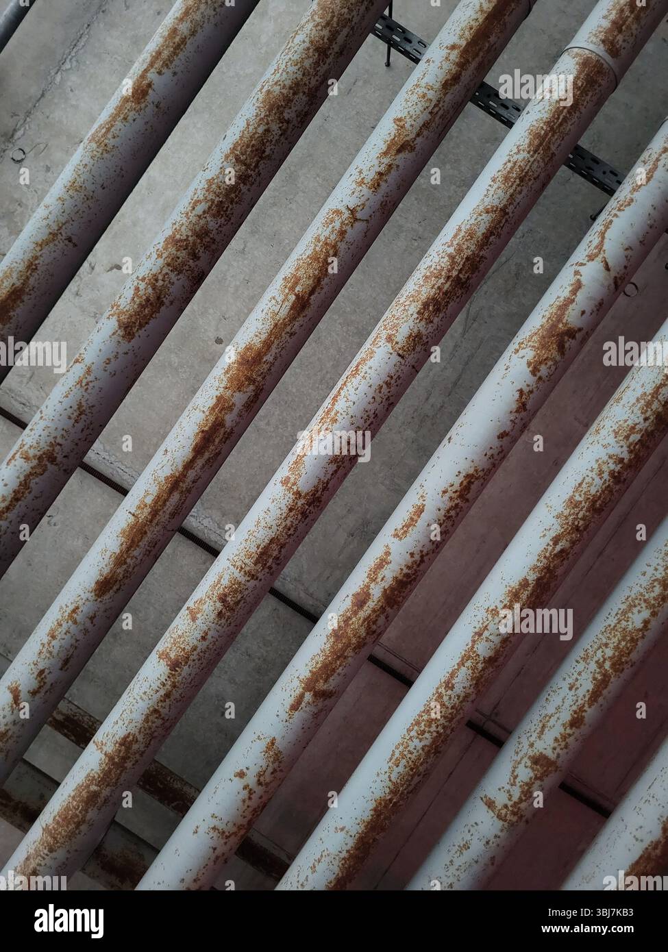 Rust diagonal pipes on a concrete wall in an industrial interior Stock ...