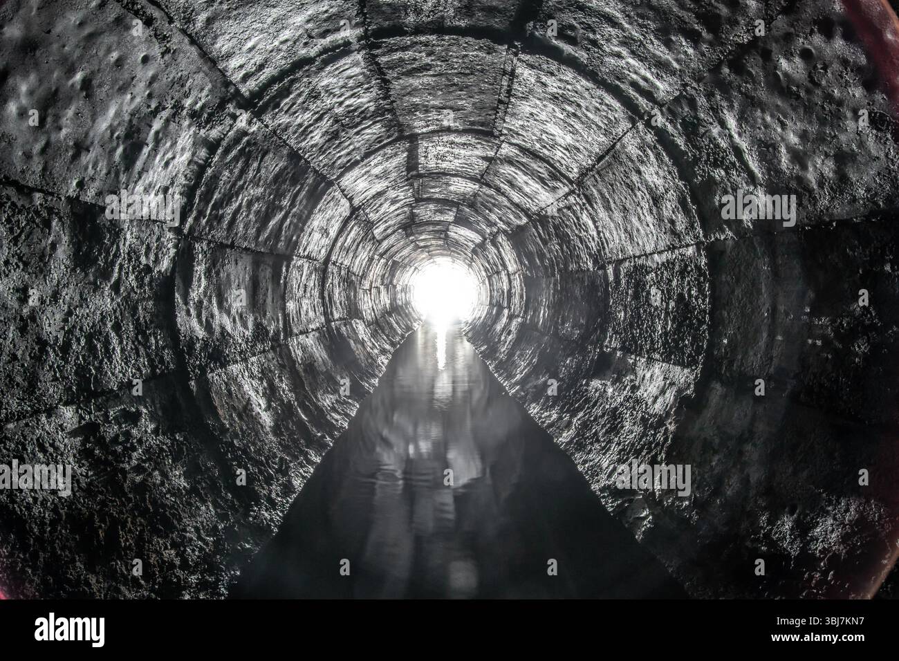 Round drainage concrete tunnel with water built with formwork. With ...