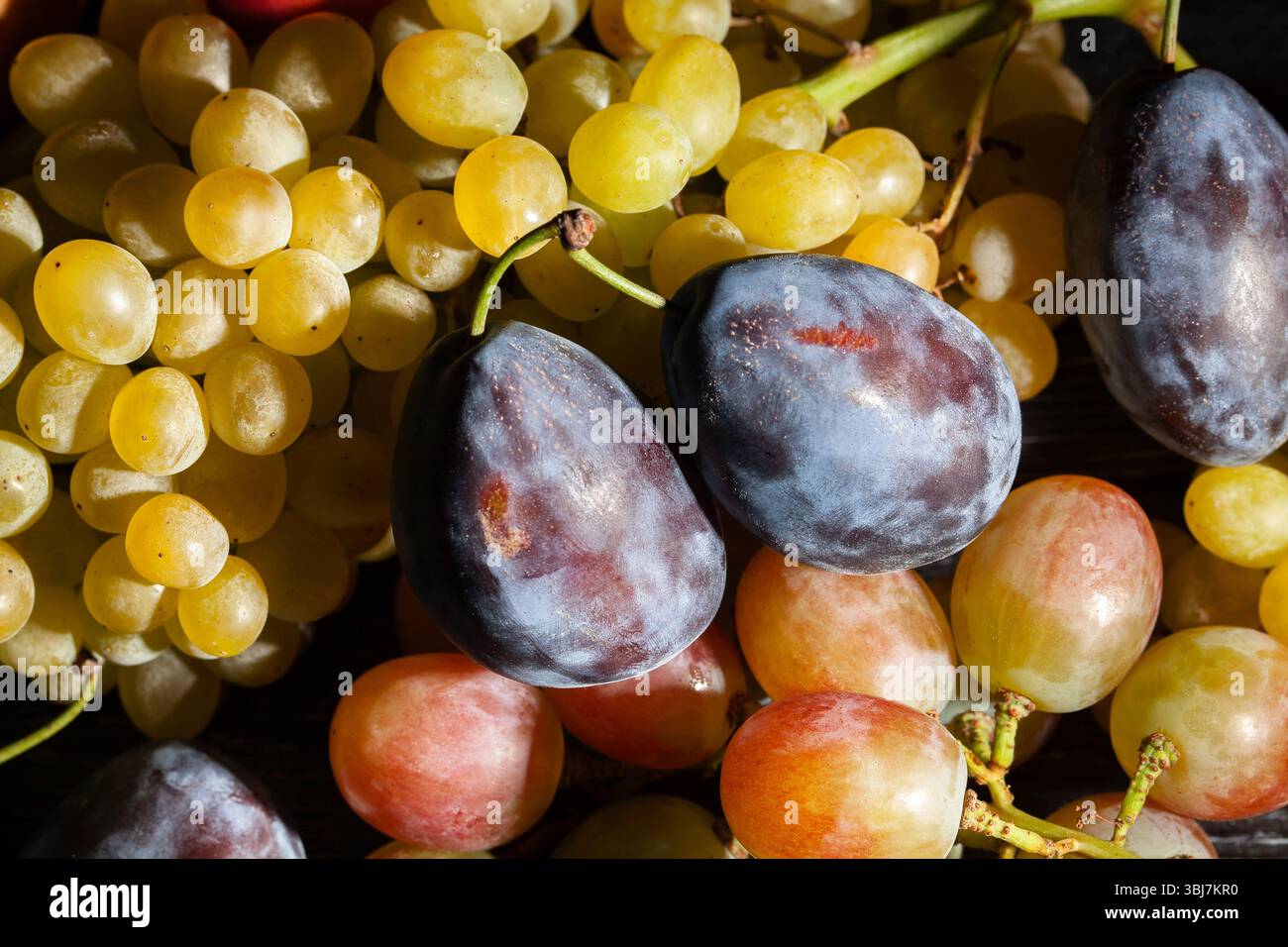 prune plum fruit mix on black background Stock Photo - Alamy