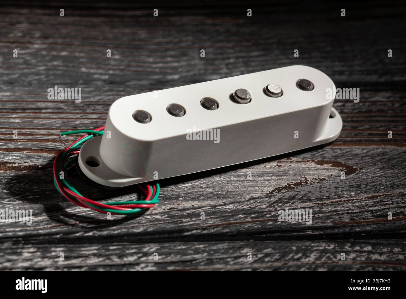 white single coil pickup on black wood background Stock Photo - Alamy