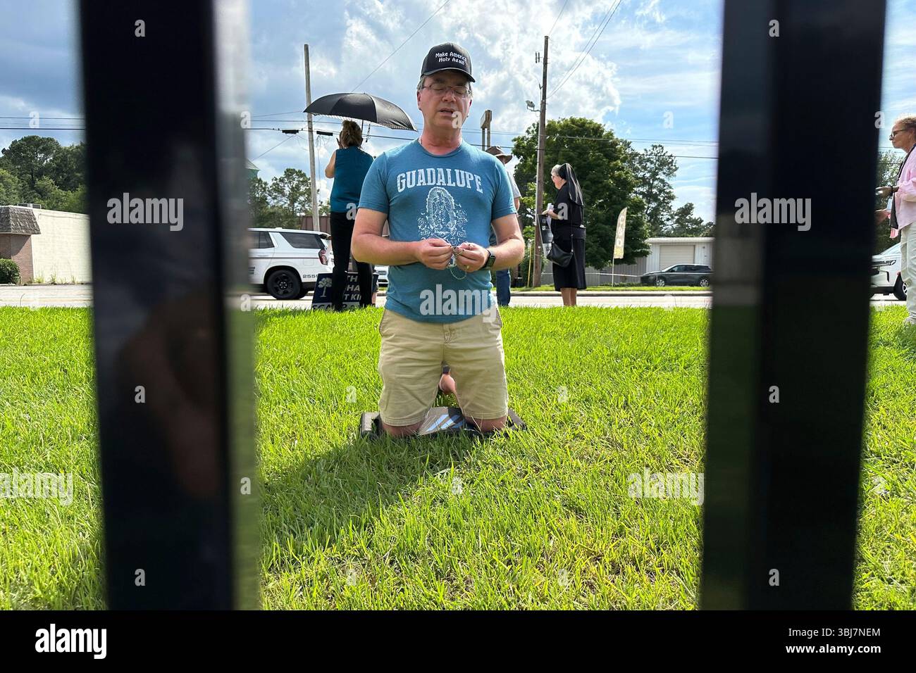 A man prays the Rosary outside the gates of the Broad River Road ...