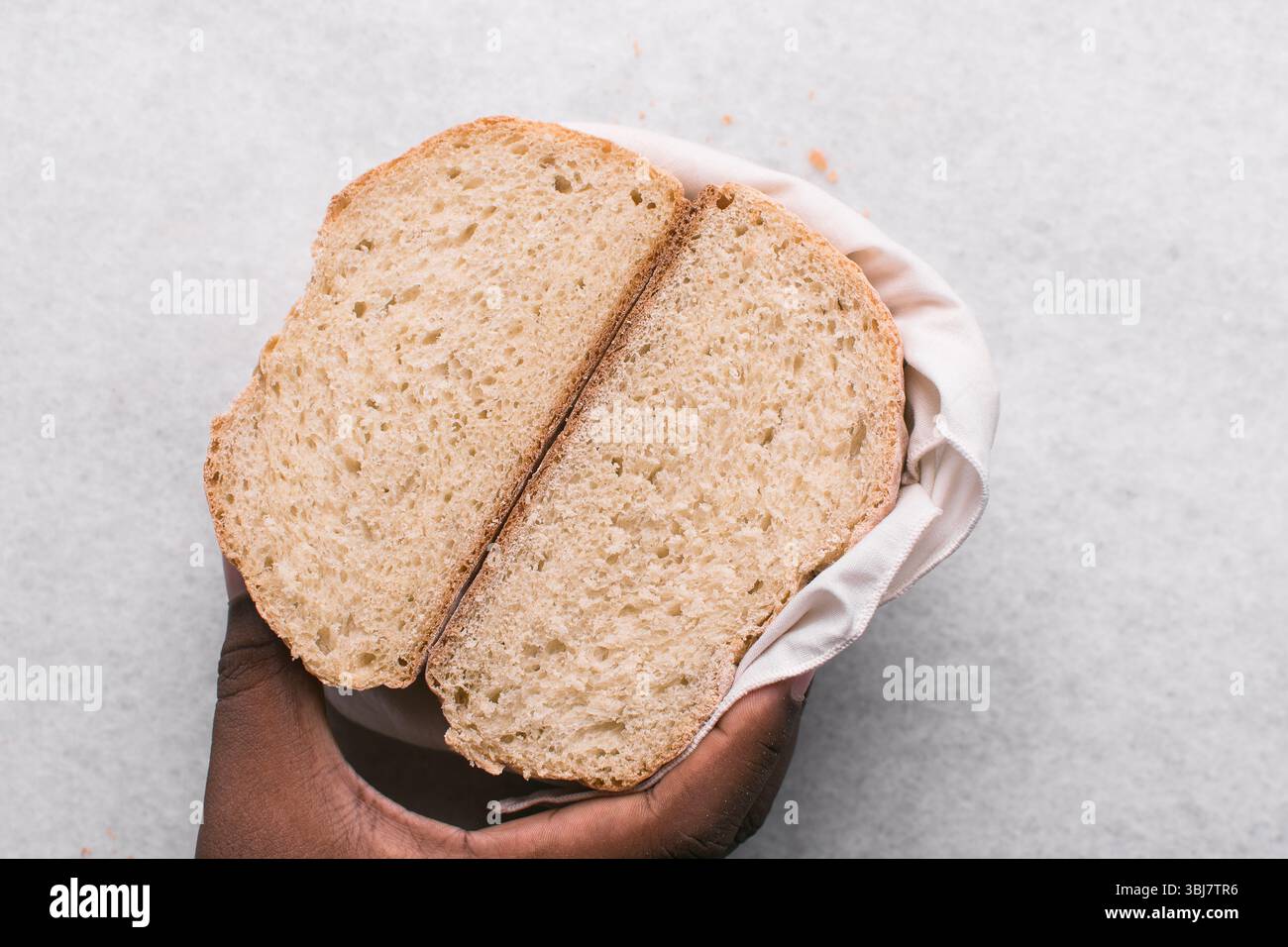 Overhead view of sliced homemade artisan bread on marble countertop ...
