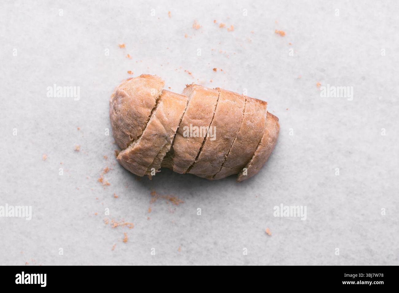 Overhead view of sliced homemade artisan bread on marble countertop ...