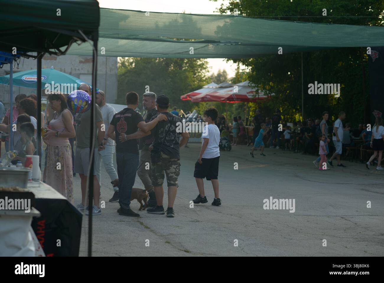People gather in the evening shade during the first day of the annual ...