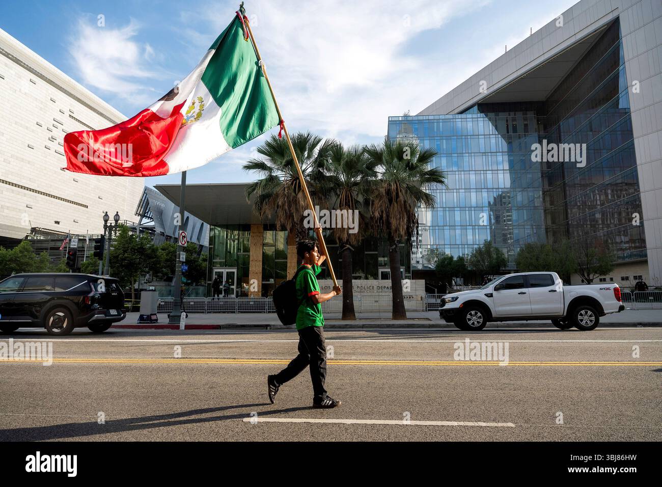 Alberto Gonzalez carries a Mexican flag past Los Angeles Police Department headquarters while ...