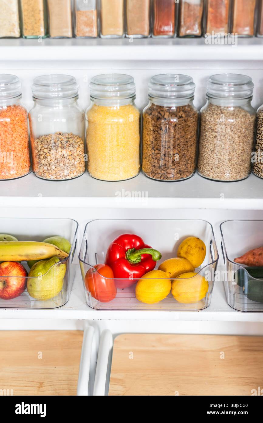 small organized pantry with matching clear jars filled with grains ...